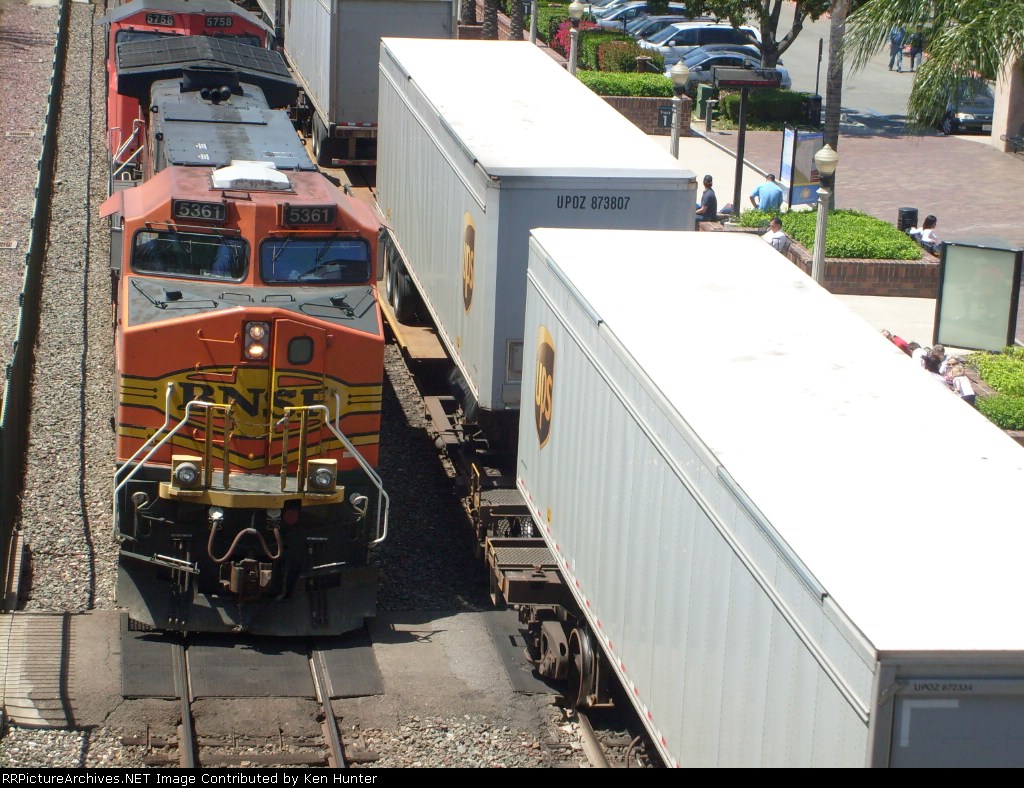 BNSF #5361 stopped in the station waiting for the frieght train (right) to clear the way.